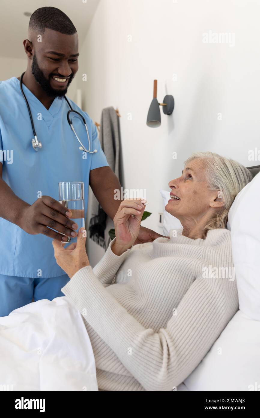 African american male health worker giving a glass of water to ...