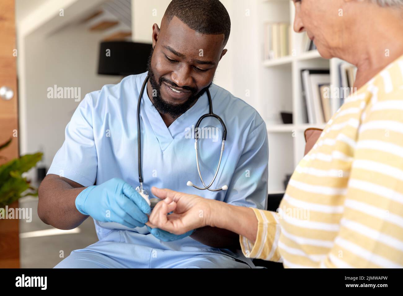African american male health worker measuring blood sugar of caucasian ...