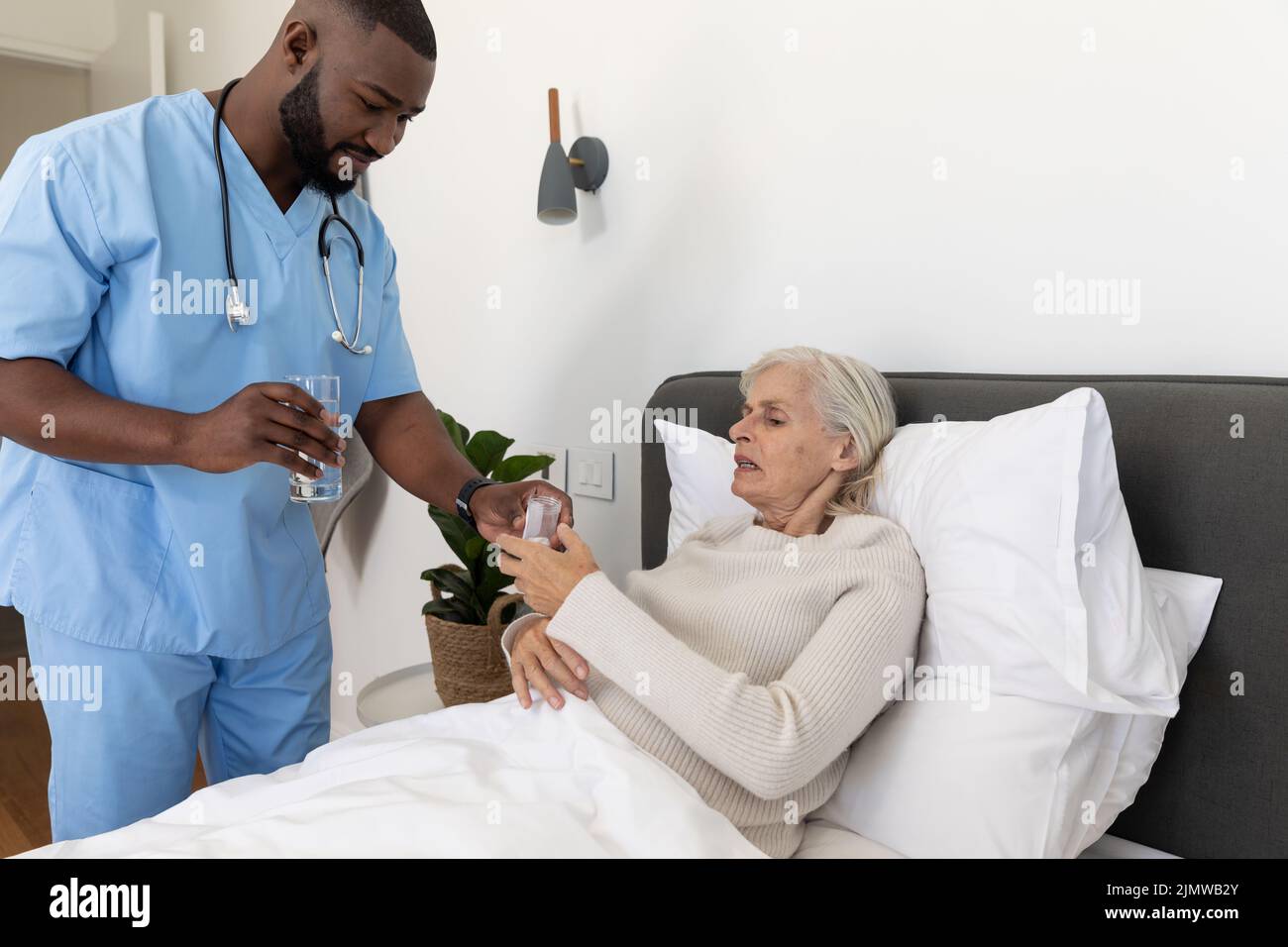 African american male health worker giving medical pills to caucasian ...