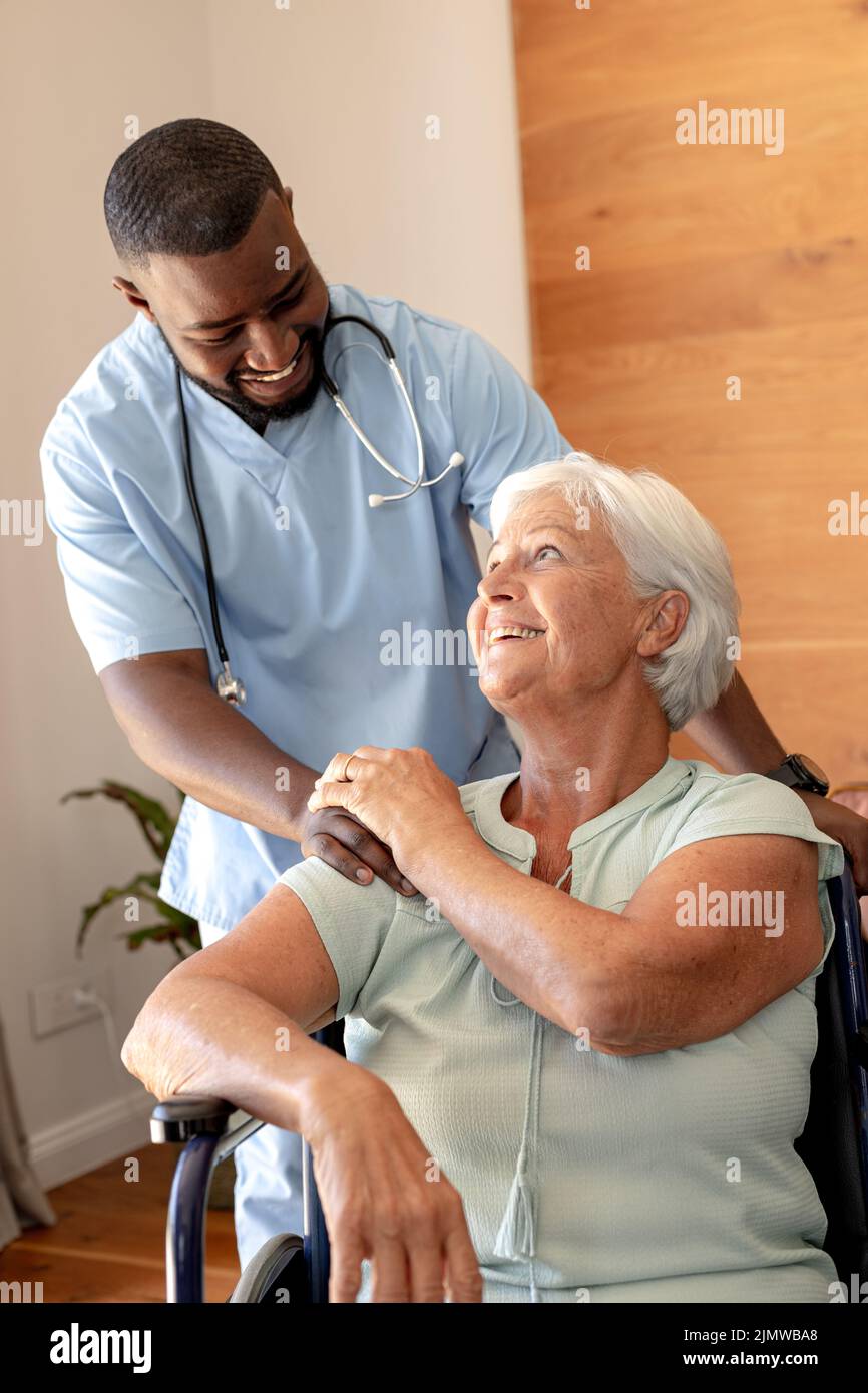 African american male health worker supporting caucasian senior woman ...