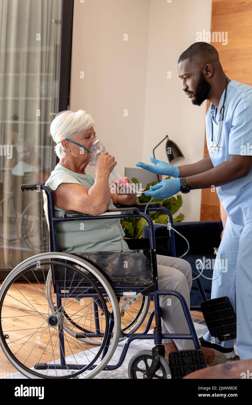 African american male health worker helping caucasian senior woman to ...