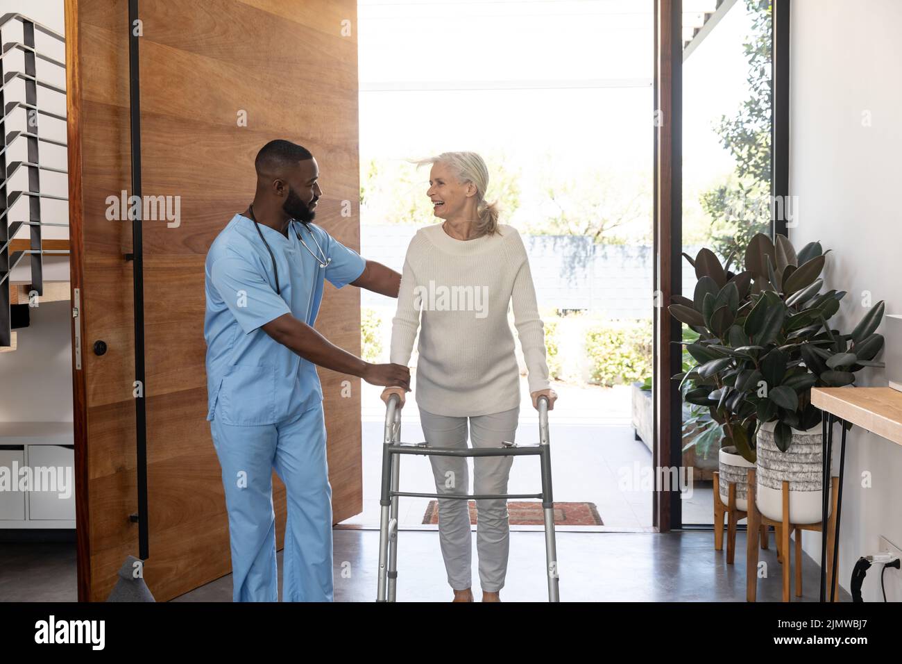 African american male health worker helping caucasian senior woman to ...
