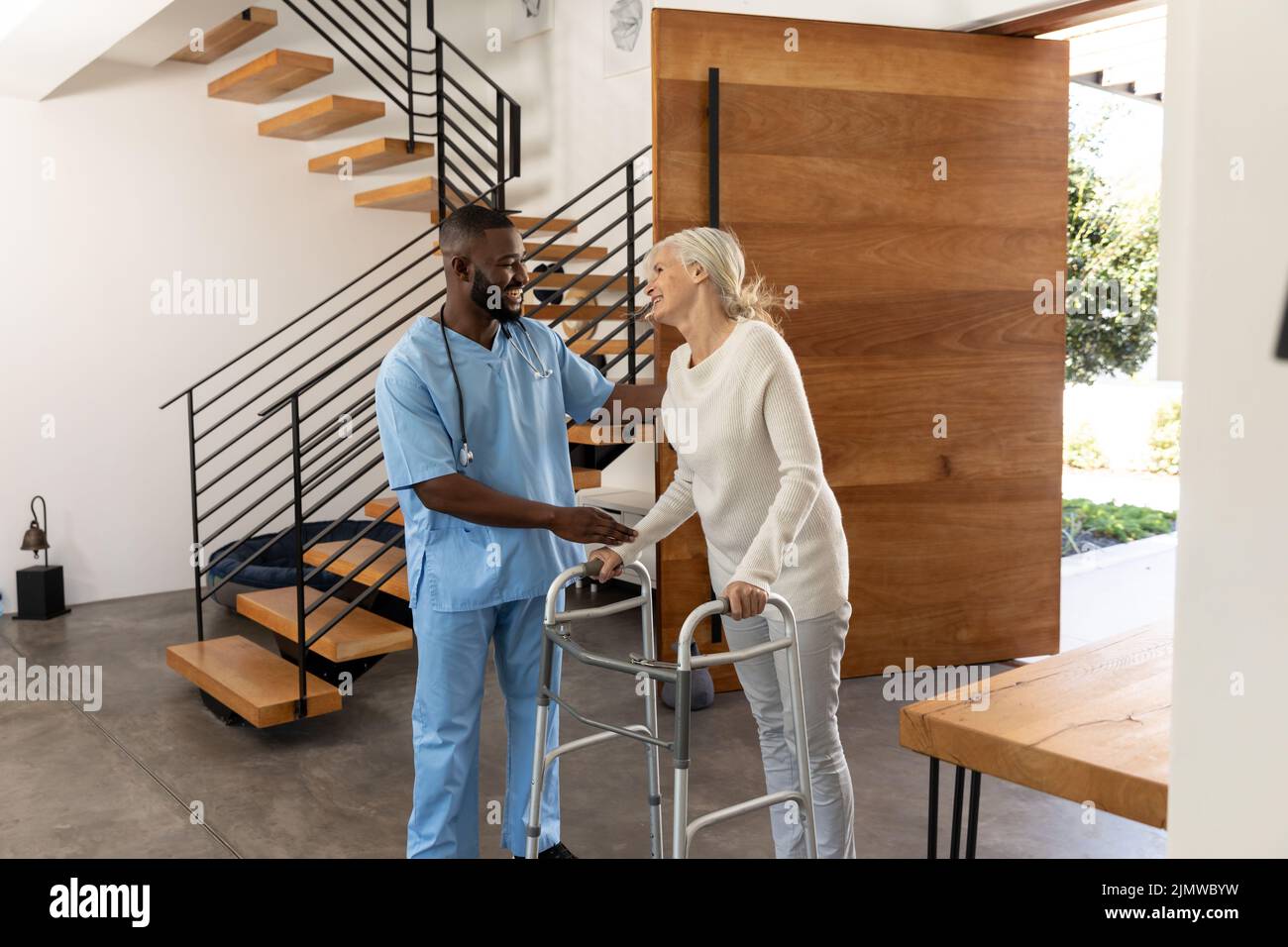 African american male health worker helping caucasian senior woman to ...