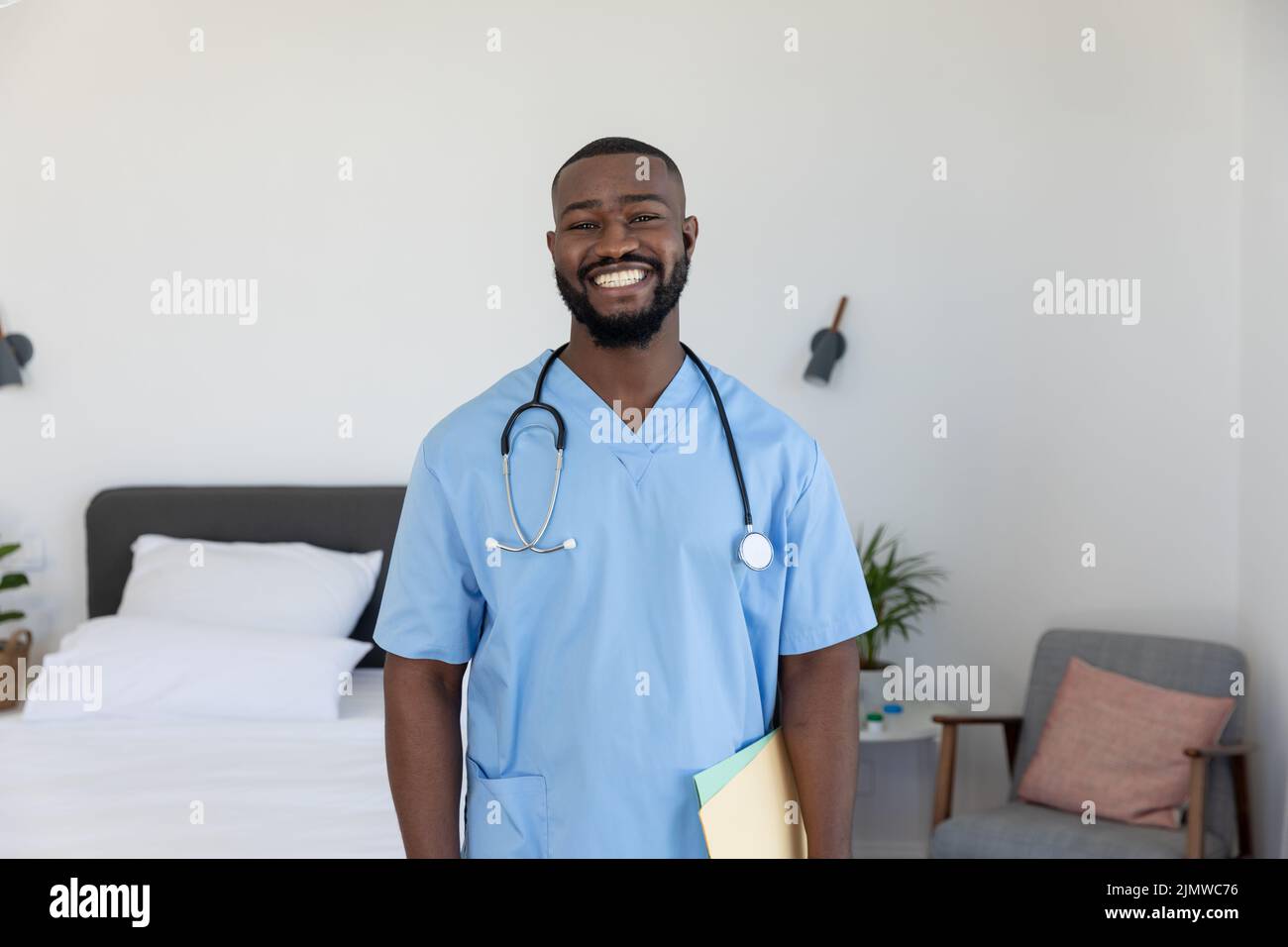 Portrait of african american male health worker holding a file smiling ...