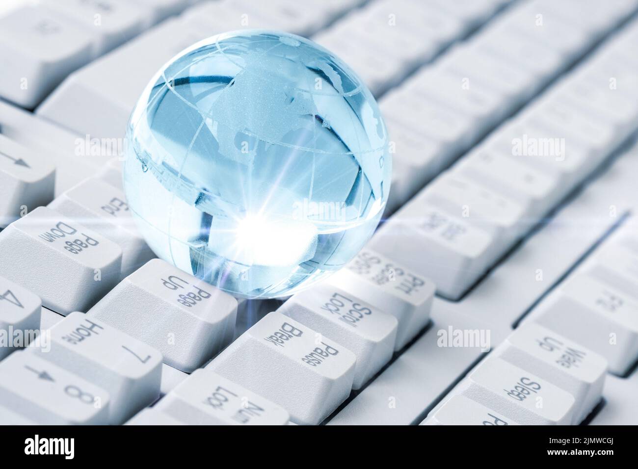Crystal Earth globe on computer keyboard Stock Photo - Alamy