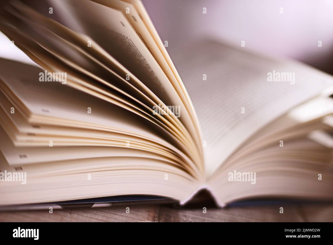 Composition with open book on the table Stock Photo - Alamy