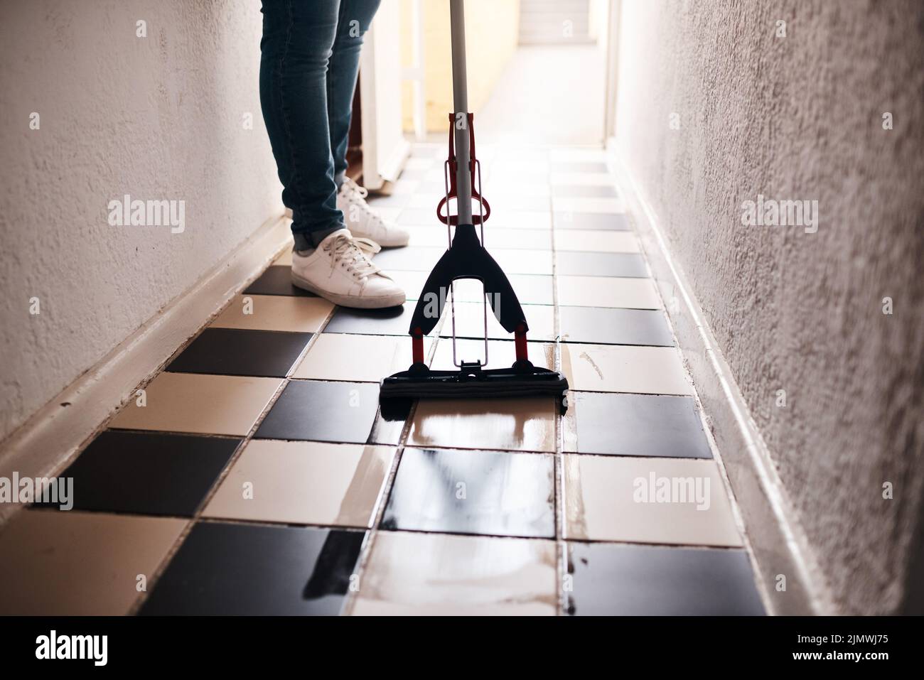 Keeping a clean home. an unrecognizable man mopping the floor at home ...