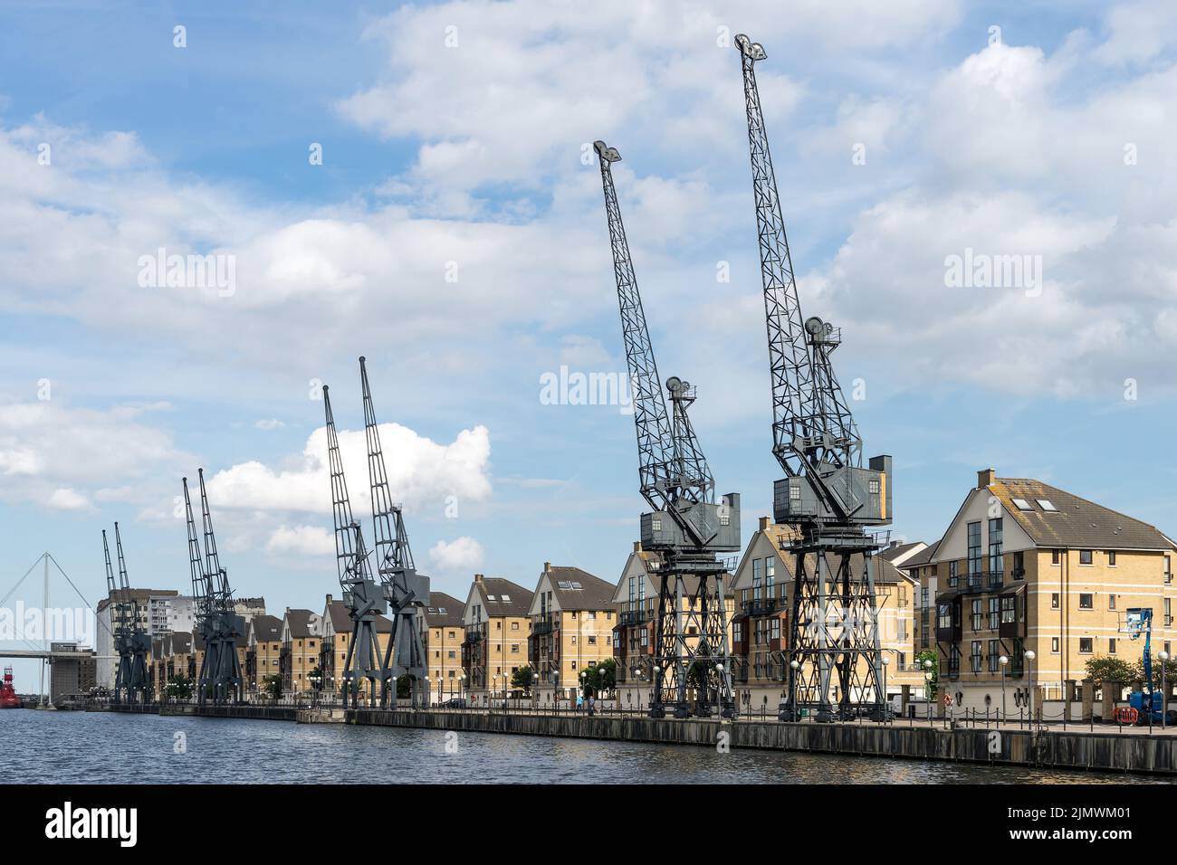 Old dockside cranes alongside a waterfront development Stock Photo - Alamy