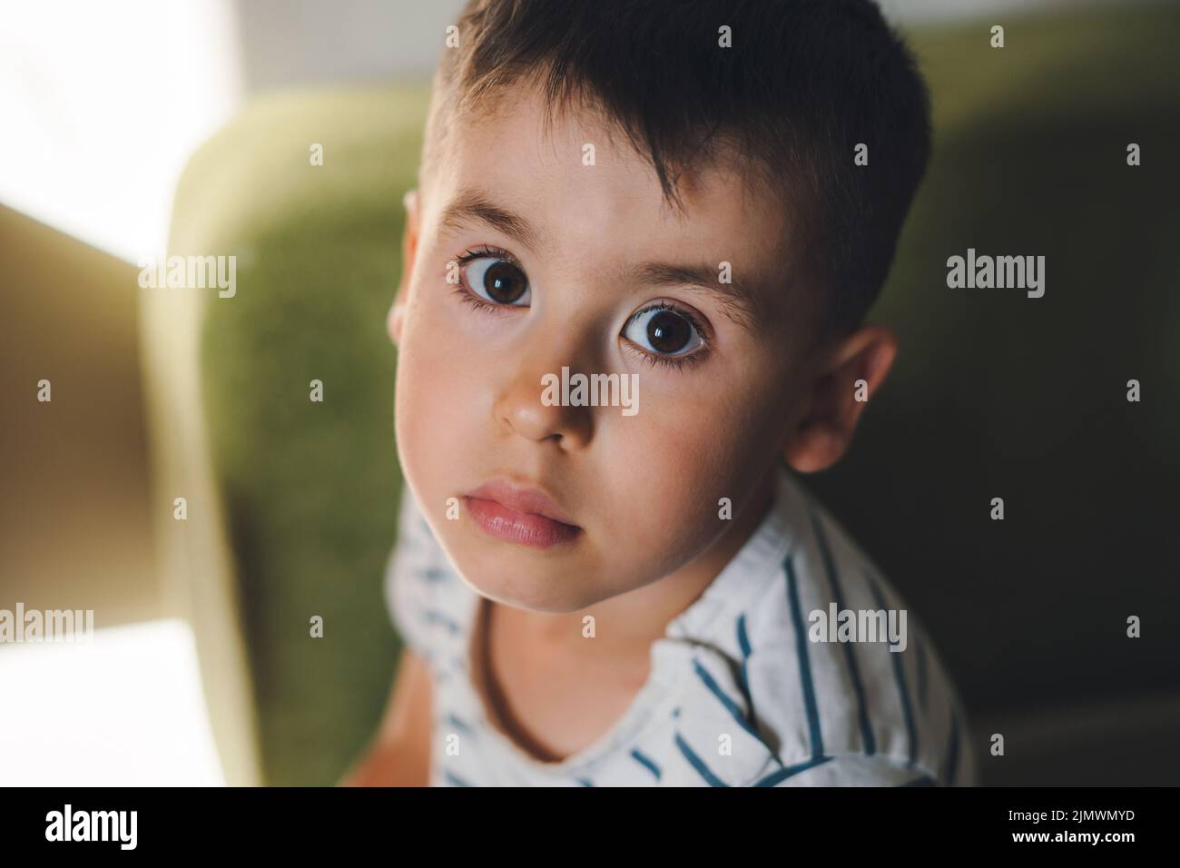 The portrait of a boy looking sadly straight into the camera. Head shot ...