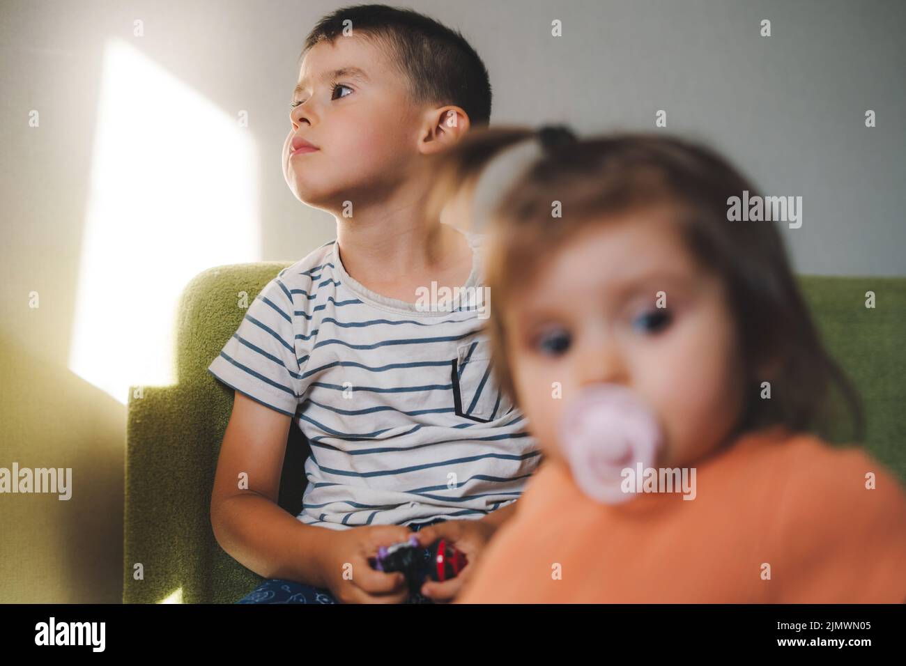 Two children waiting at home on the couch for their parents to return ...