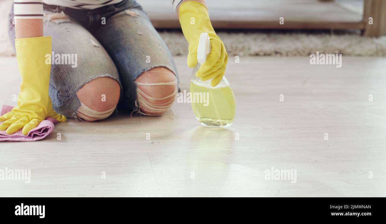 I keep my floors clean at all times. a young woman cleaning her floors ...