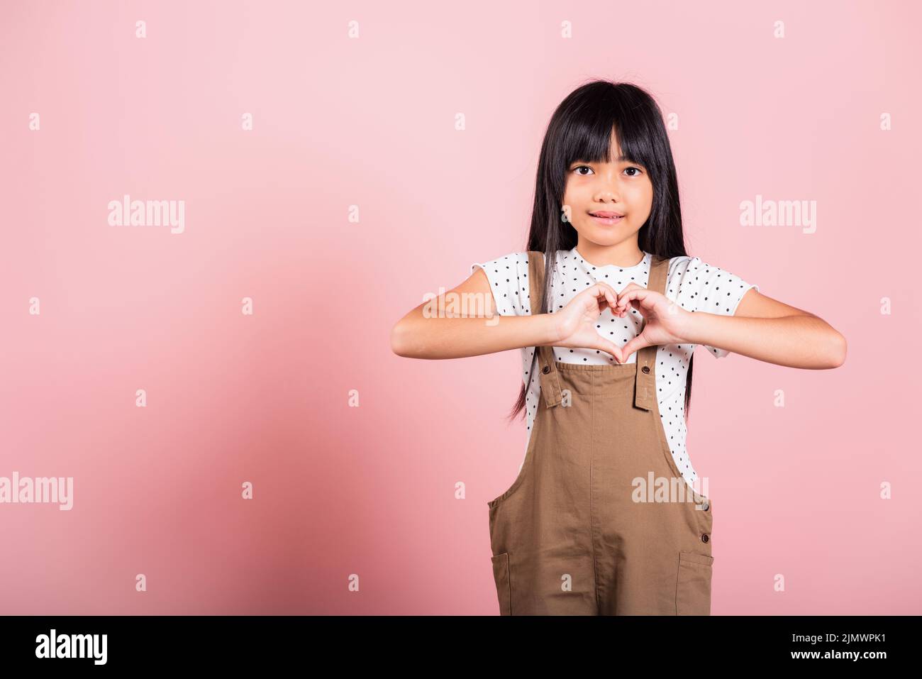 Asian little kid 10 years old showing heart sign at studio shot ...