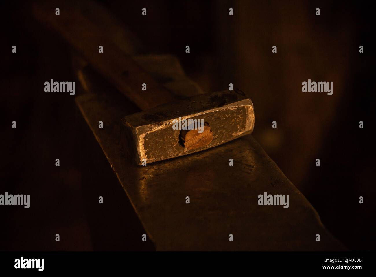 Glowing hammer lying on the anvil in dark lighting Stock Photo - Alamy
