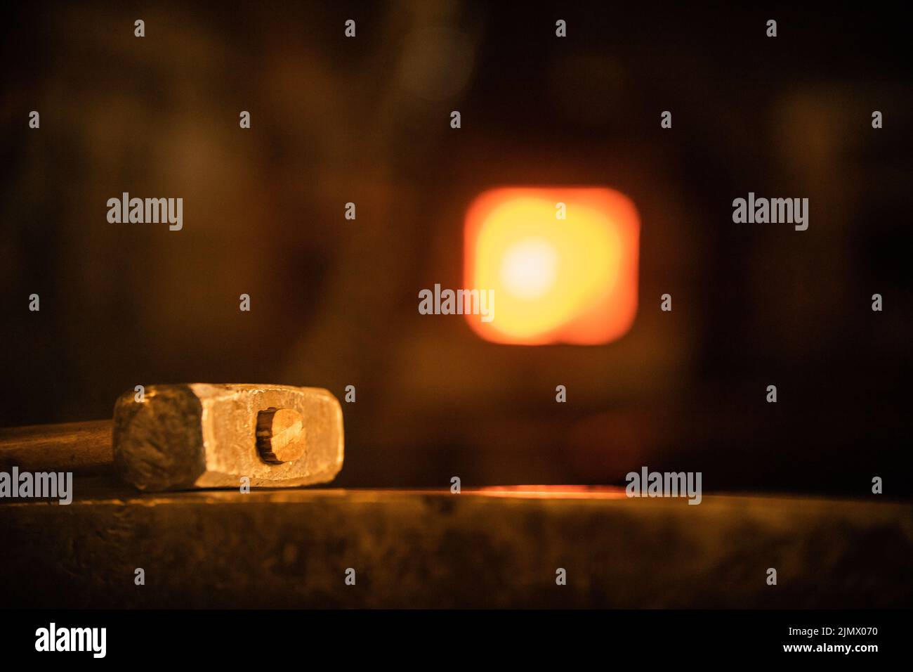 Glowing hammer on the anvil in dark lighting in the workshop Stock ...