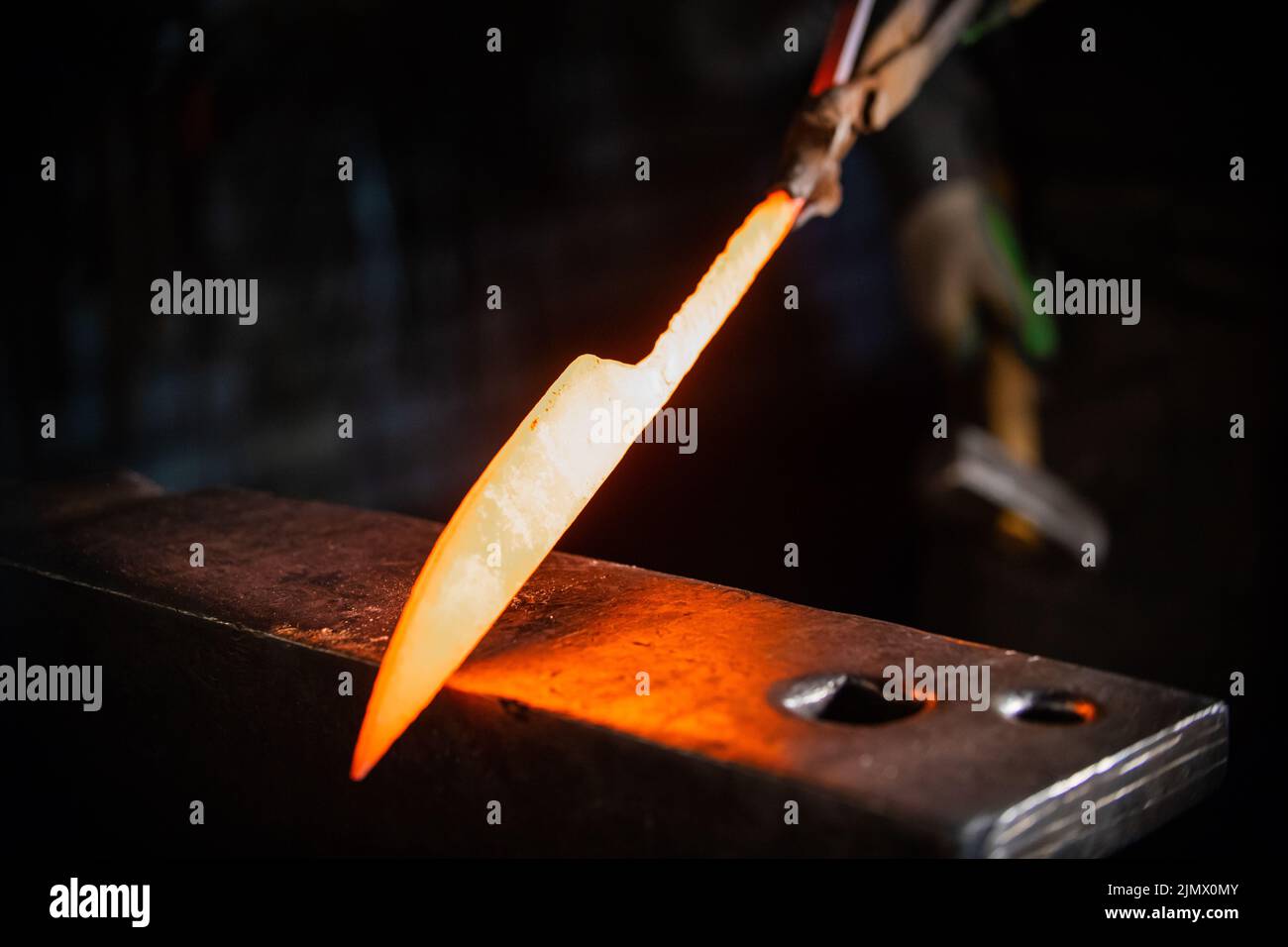 Forging a knife out of the hot metal - holding the knife in forceps ...