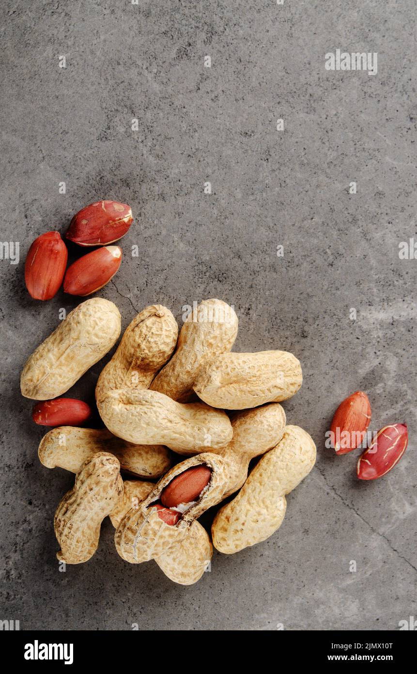 Flat lay view at peanuts in shell on stone table. Healthy eating ...