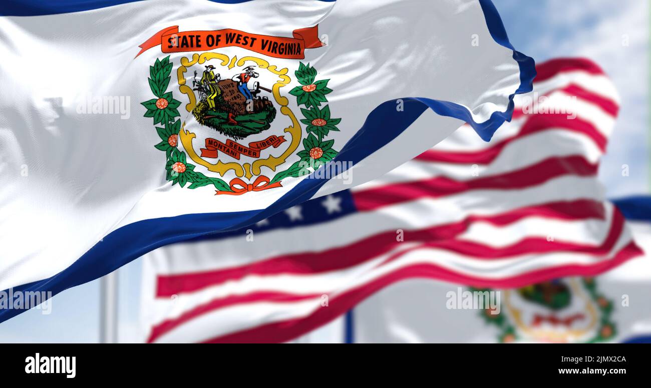The West Virginia state flag waving along with the national flag of the ...
