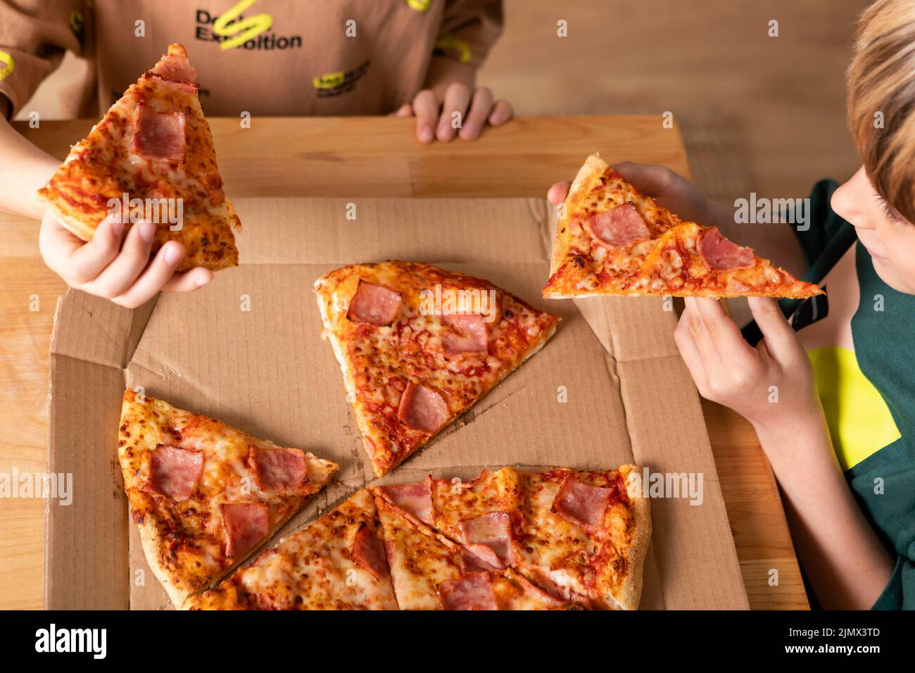 Kids eating pizzas together Stock Photo - Alamy