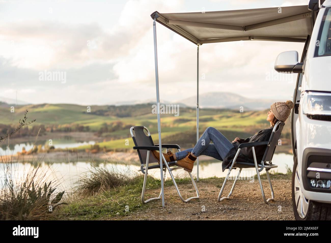 Front view road trip car lake with woman relaxing Stock Photo - Alamy