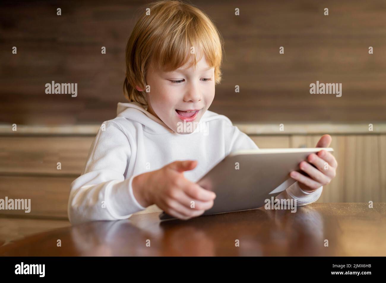 Front view young boy using tablet table Stock Photo - Alamy