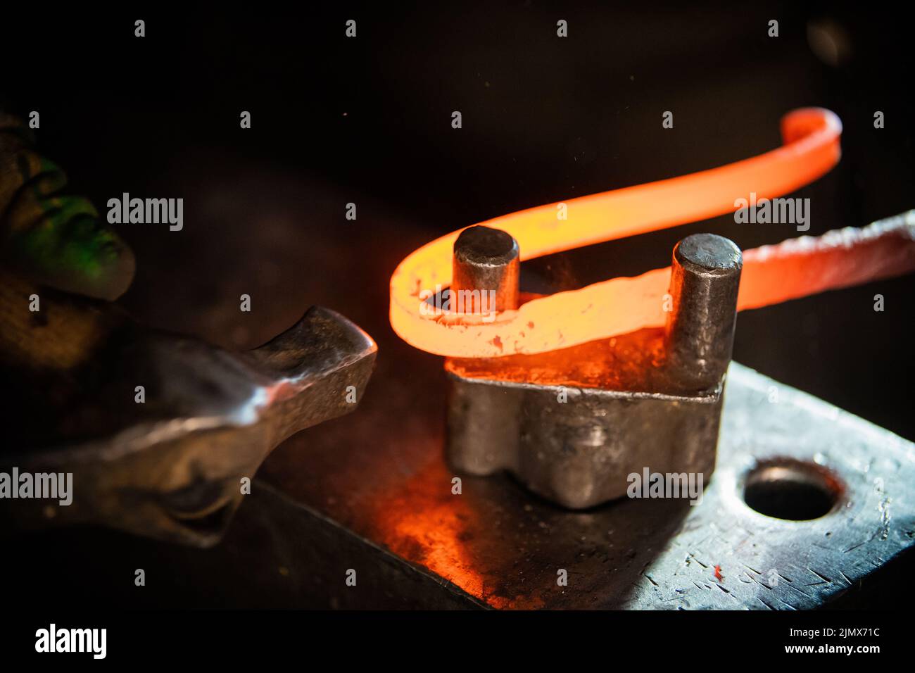 A blacksmith making a unique handle for the knife - bending the metal ...