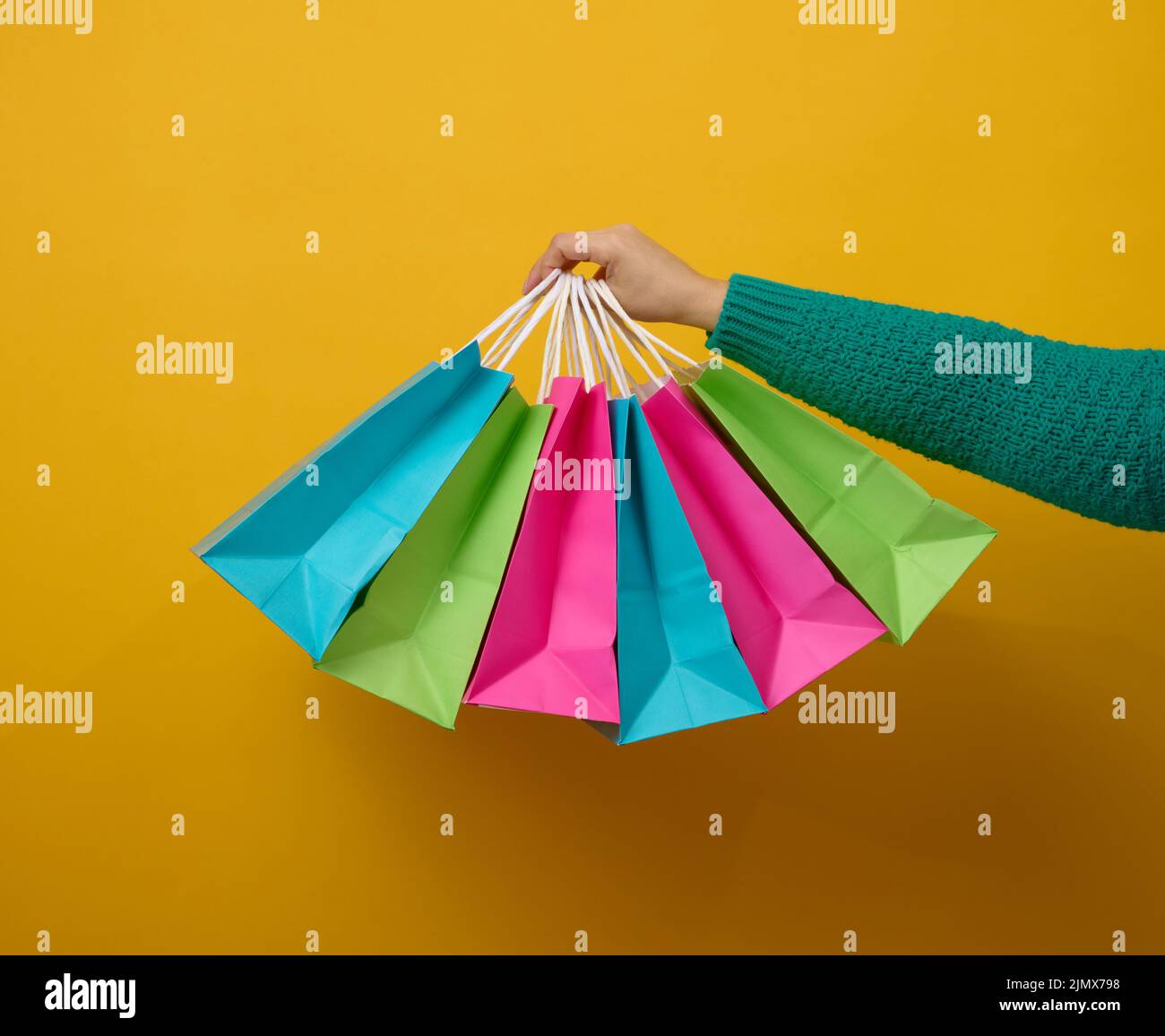 Female hand holds a paper disposable bag with handles for groceries and ...