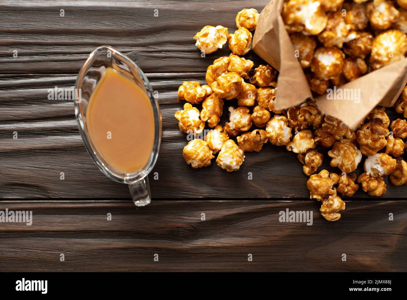 Caramelized popcorn in paper bag on wooden kitchen table flat lay Stock ...