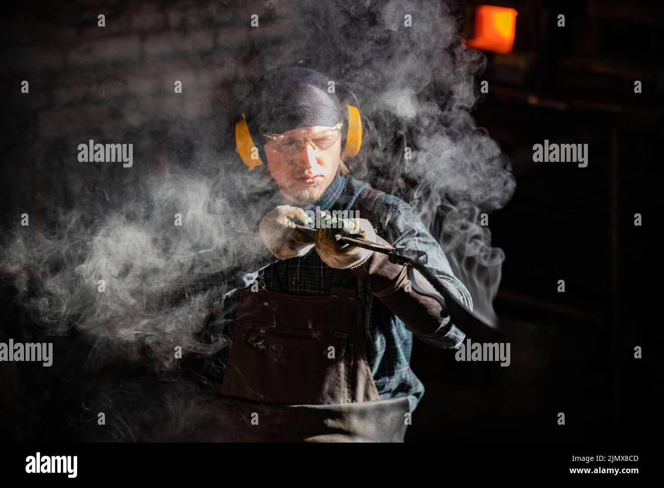 Blacksmith man worker making a unique knife Stock Photo - Alamy