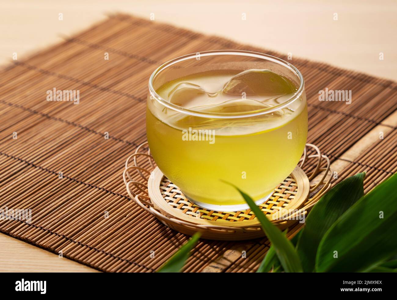 Cold Japanese green tea placed on a bamboo luncheon mat. Green tea with ...
