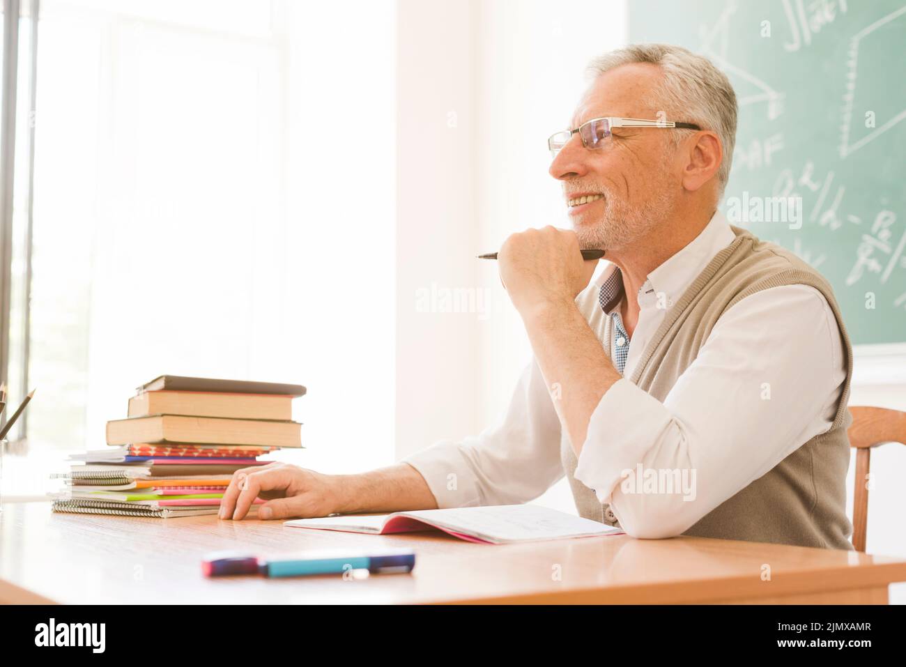Elderly lecturer sitting desk auditorium Stock Photo - Alamy