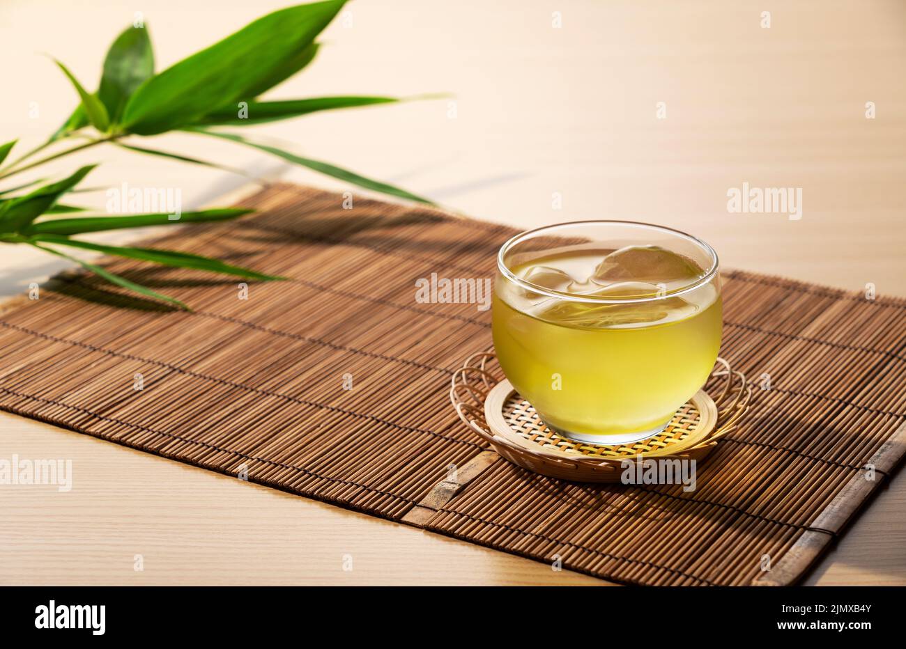 Cold Japanese green tea placed on a bamboo luncheon mat. Green tea with ...