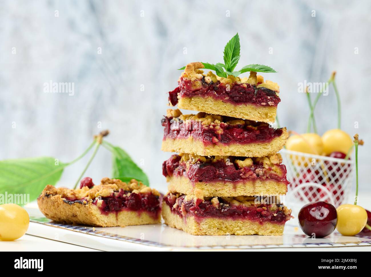 Square slices of cherry crumble lie in a stack on a white board Stock ...