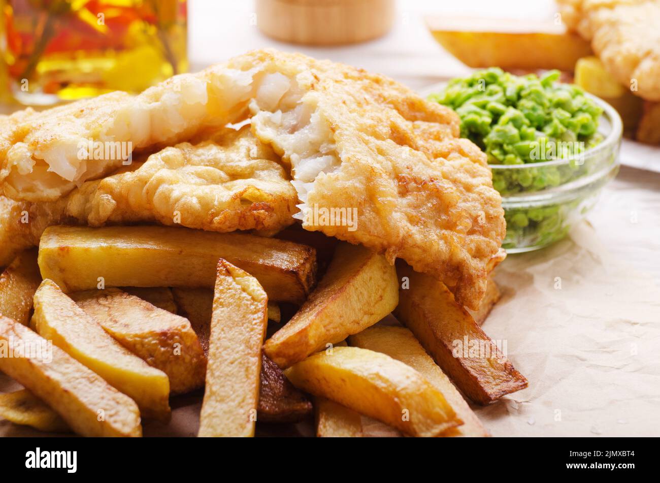 Traditional British street food fish and chips with mushy peas on parchment paper Stock Photo ...