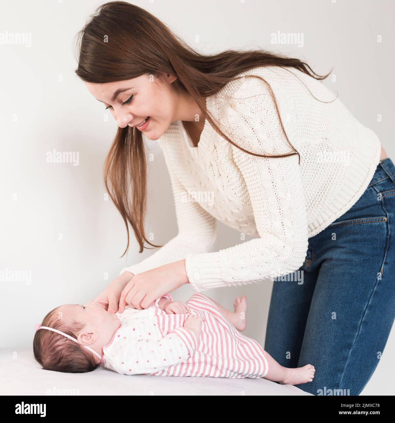 Cheerful woman taking care baby Stock Photo - Alamy