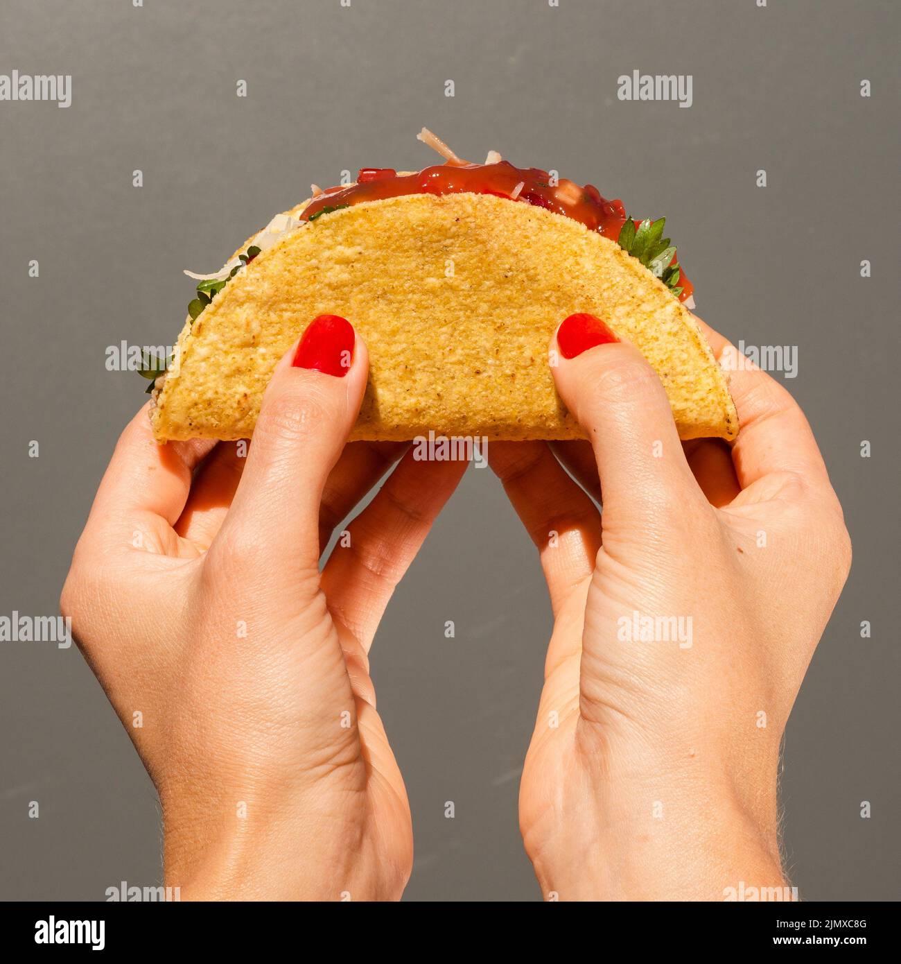 Close up person with taco grey background Stock Photo - Alamy