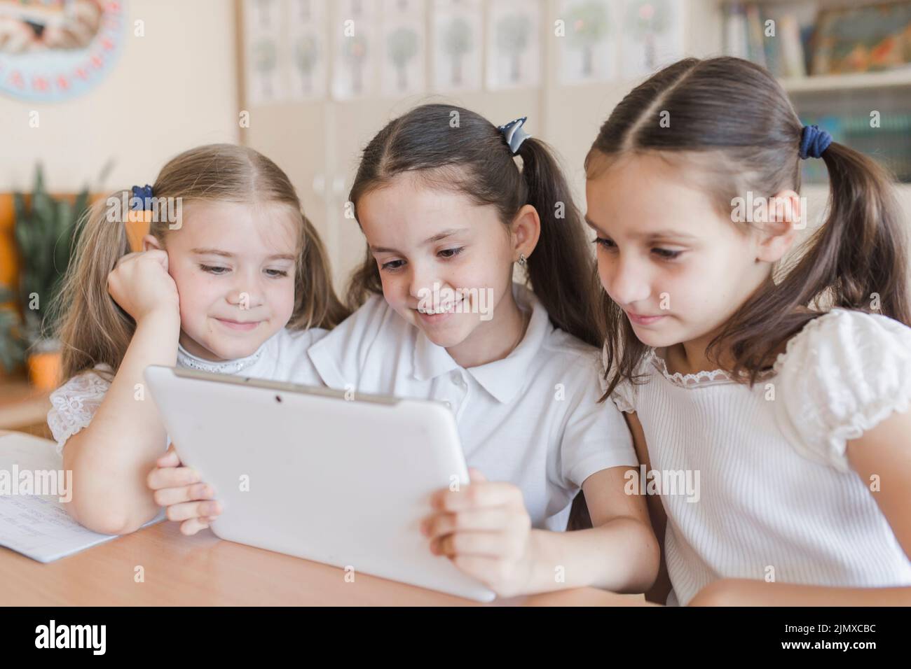 Cheerful girl using tablet classroom Stock Photo - Alamy