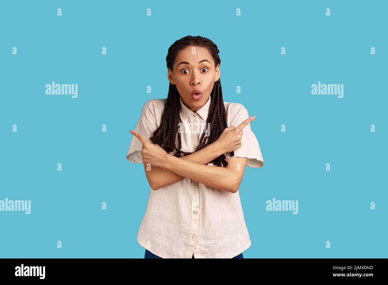 Shocked woman pointing both index fingers in different sides ...