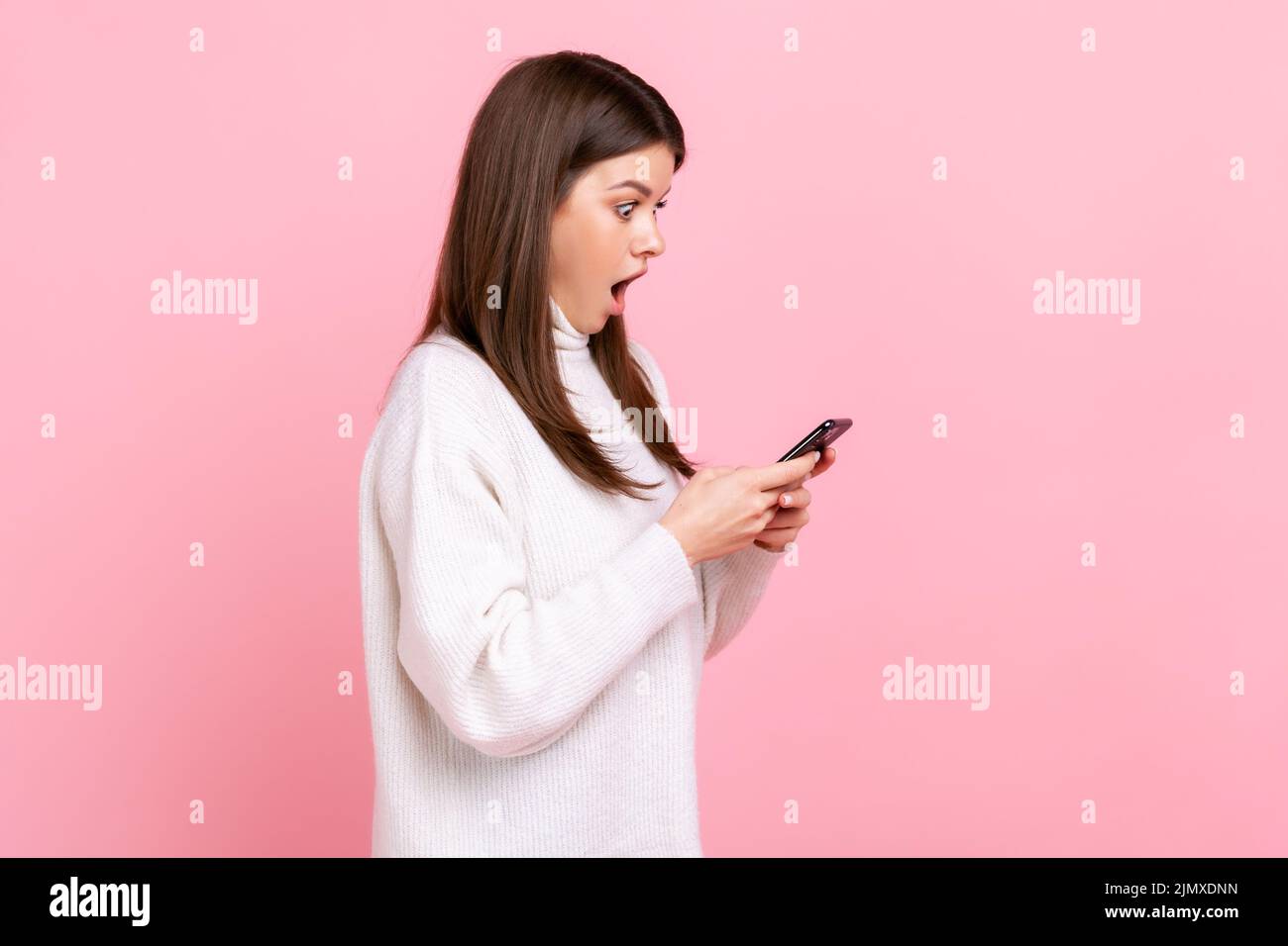 Side view portrait of shocked blogger woman standing, use smartphone ...
