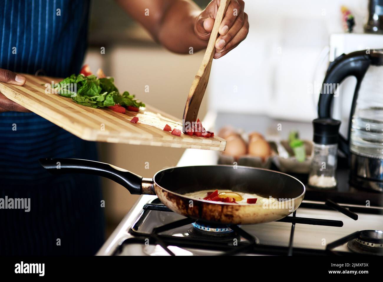 Hes quite a good cook himself. an unrecognizable man adding vegetables ...