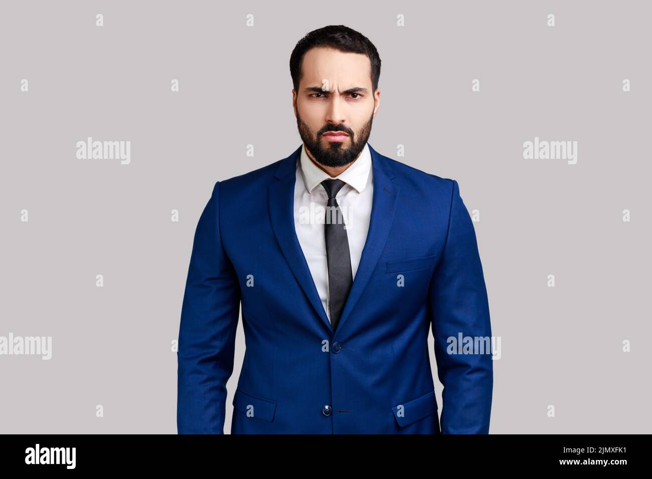 Portrait of bearded businessman looking at camera with angry face ...