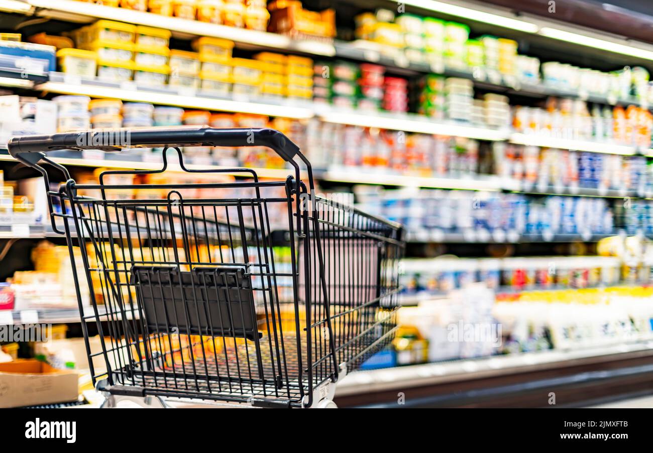 A shopping cart by a store shelf in a supermarket Stock Photo - Alamy