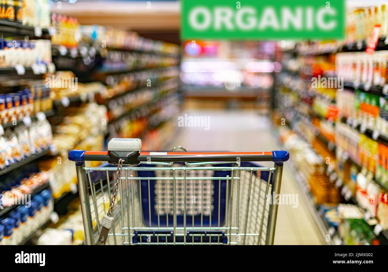 A shopping cart by a store shelf in a supermarket Stock Photo - Alamy