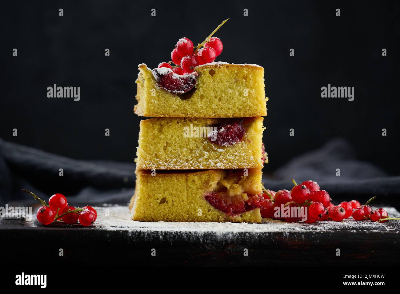 A stack of square slices of baked plum biscuit cake Stock Photo - Alamy
