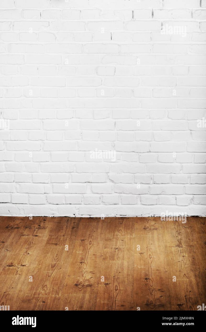 White brick wall of painted genuine clay blocks and wooden floor ...