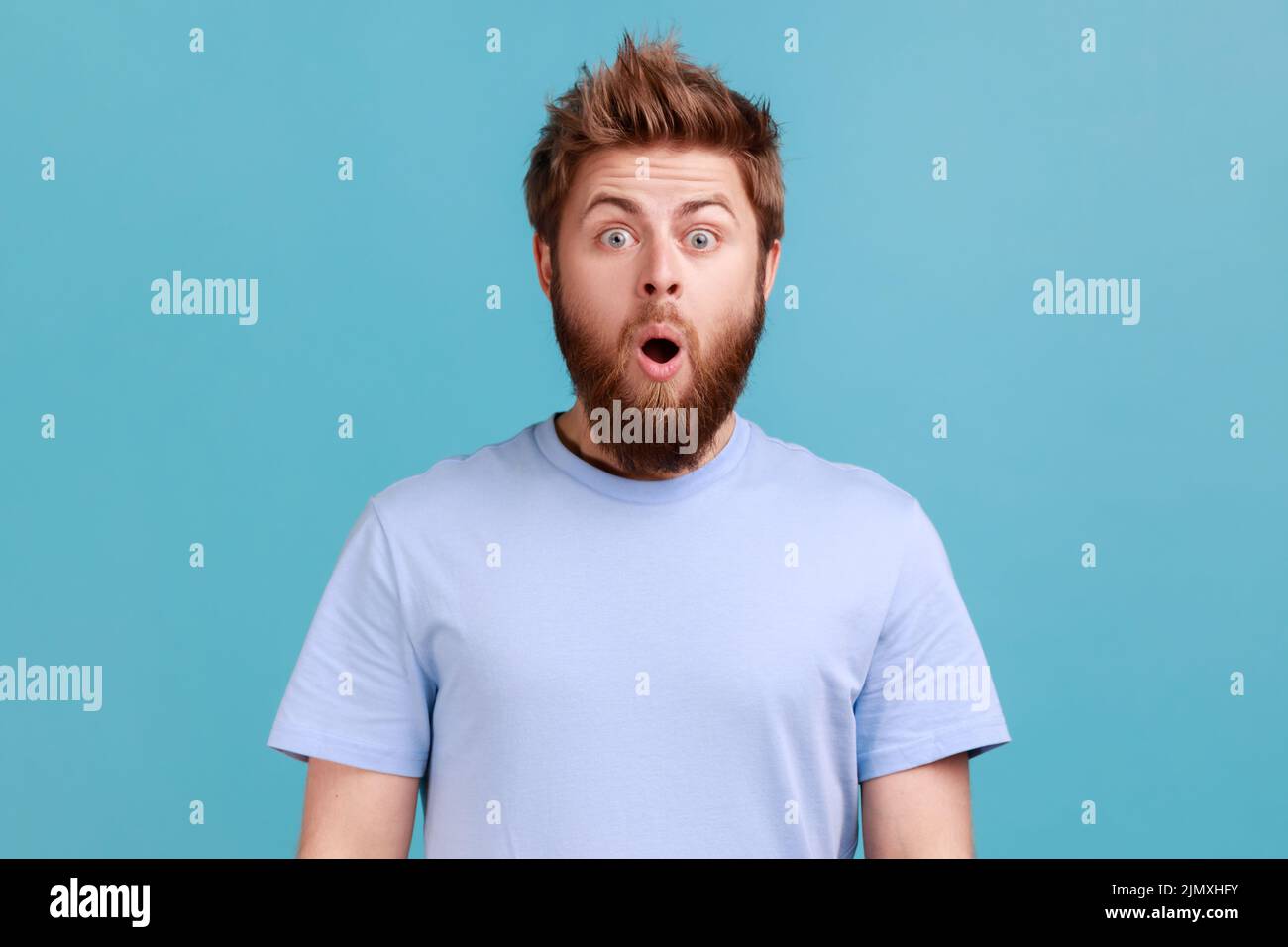 Portrait of shocked bearded man gasps from wonder, holds breath, stares ...