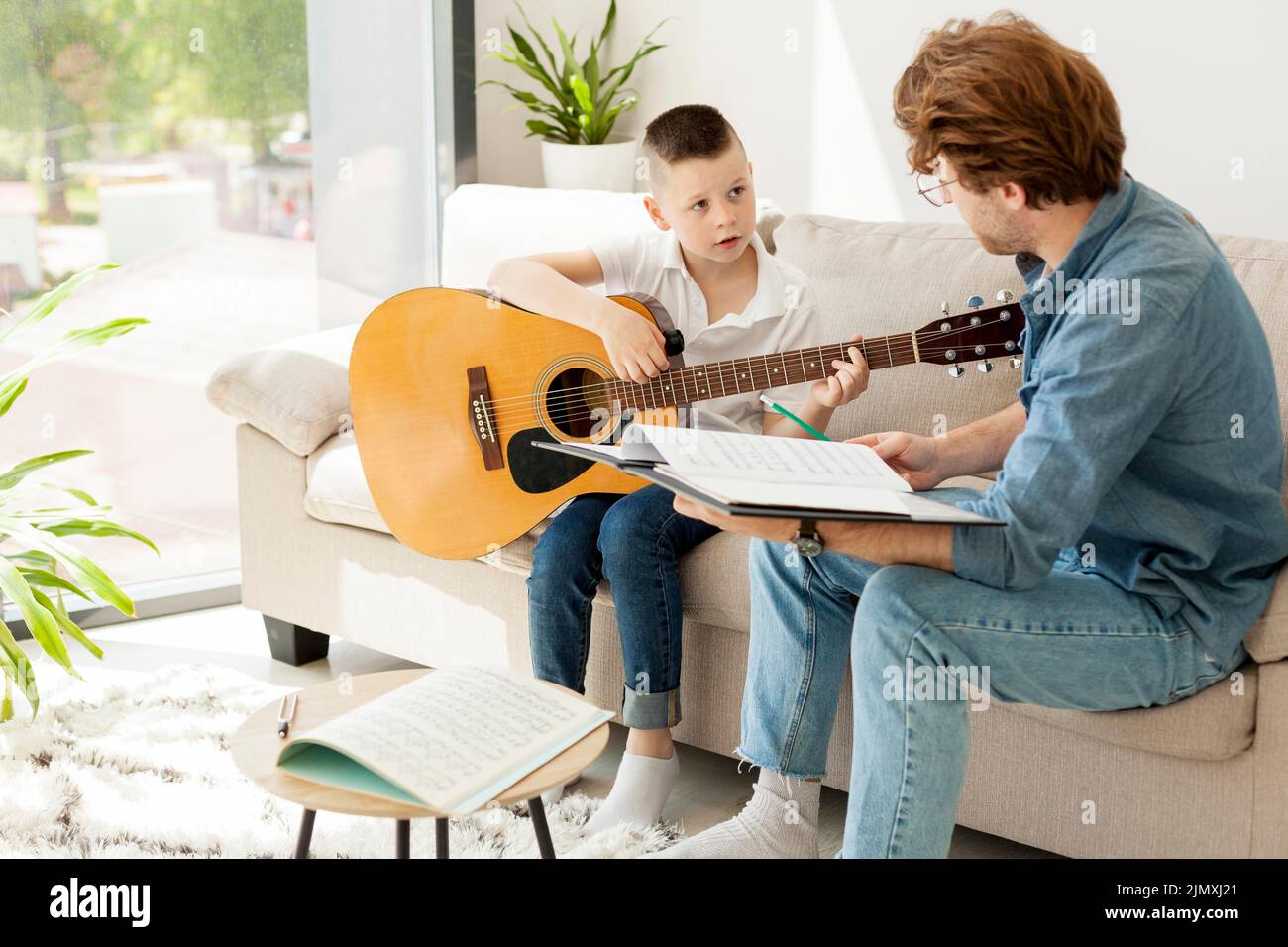 Tutor boy learning guitar from home Stock Photo - Alamy