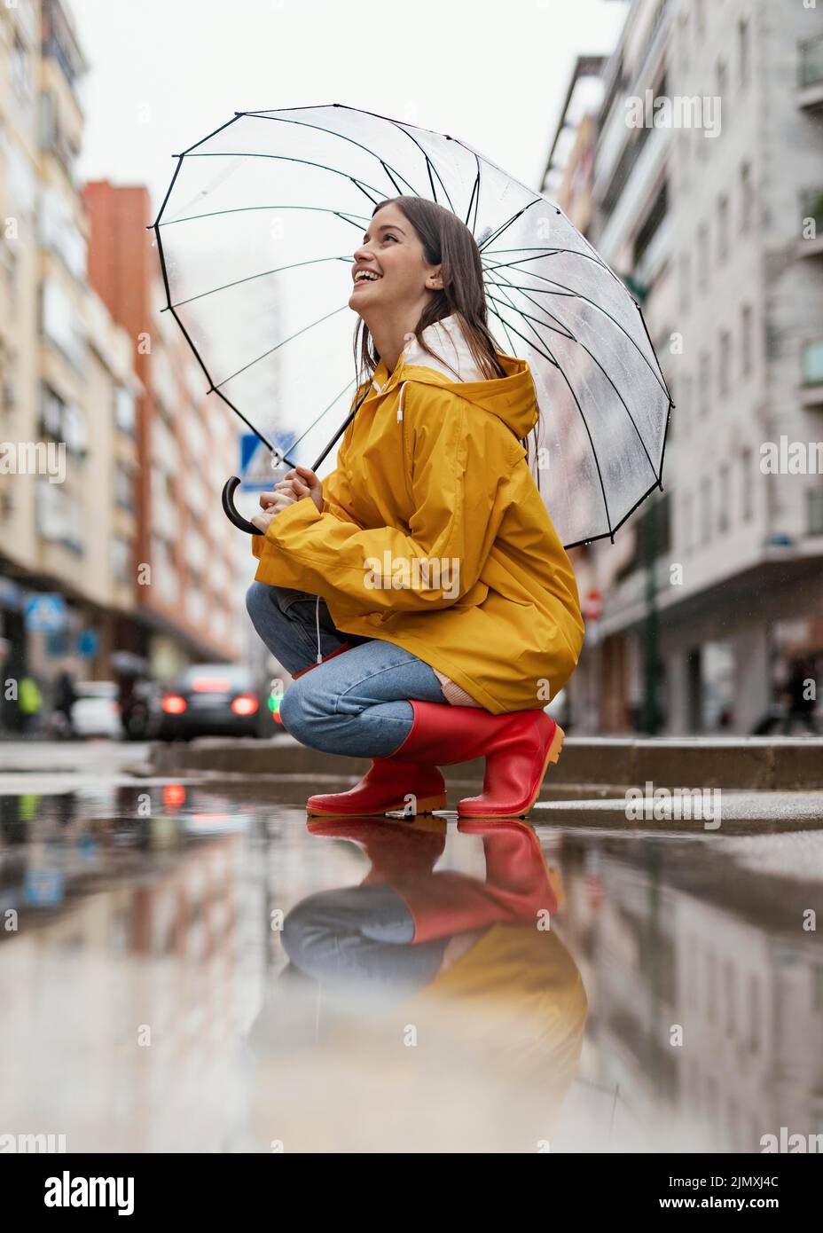 Woman with umbrella standing rain side view Stock Photo - Alamy