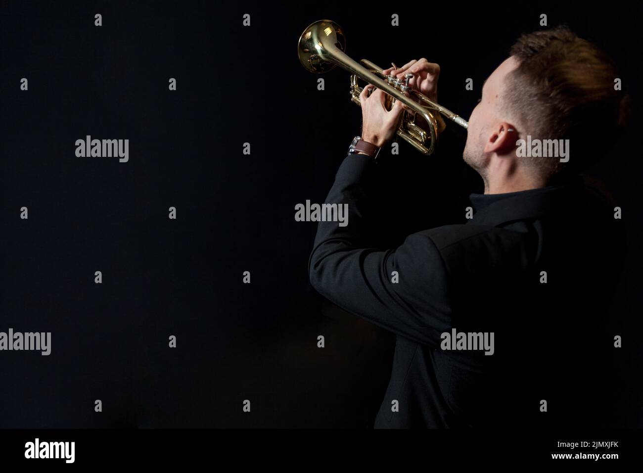 Trumpet player black background Stock Photo - Alamy