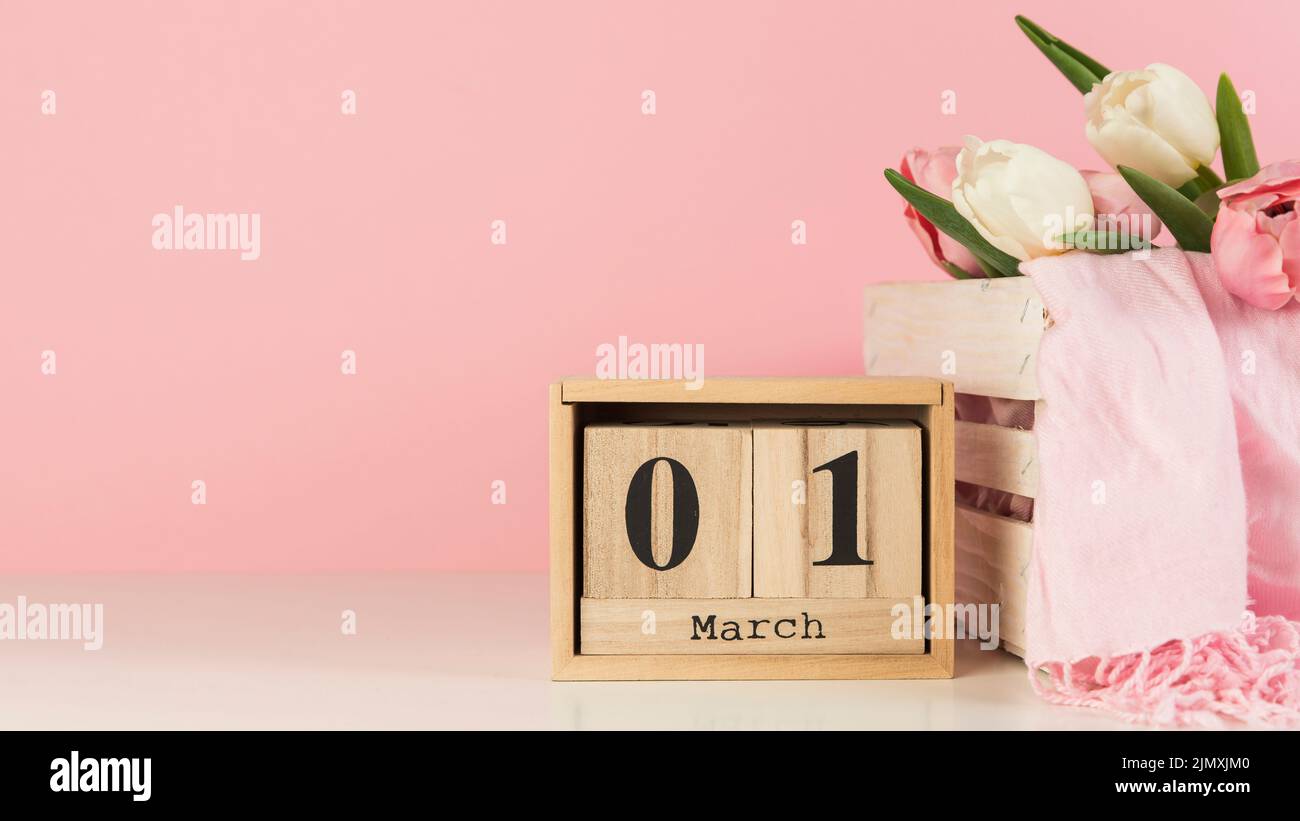 Wooden calendar with 1st march near crate with tulips scarf desk ...