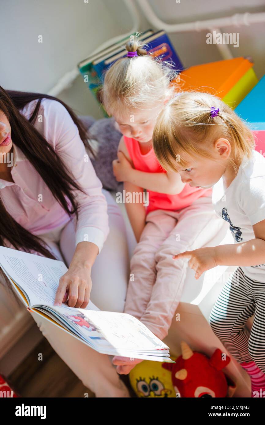 Woman reading book children Stock Photo - Alamy